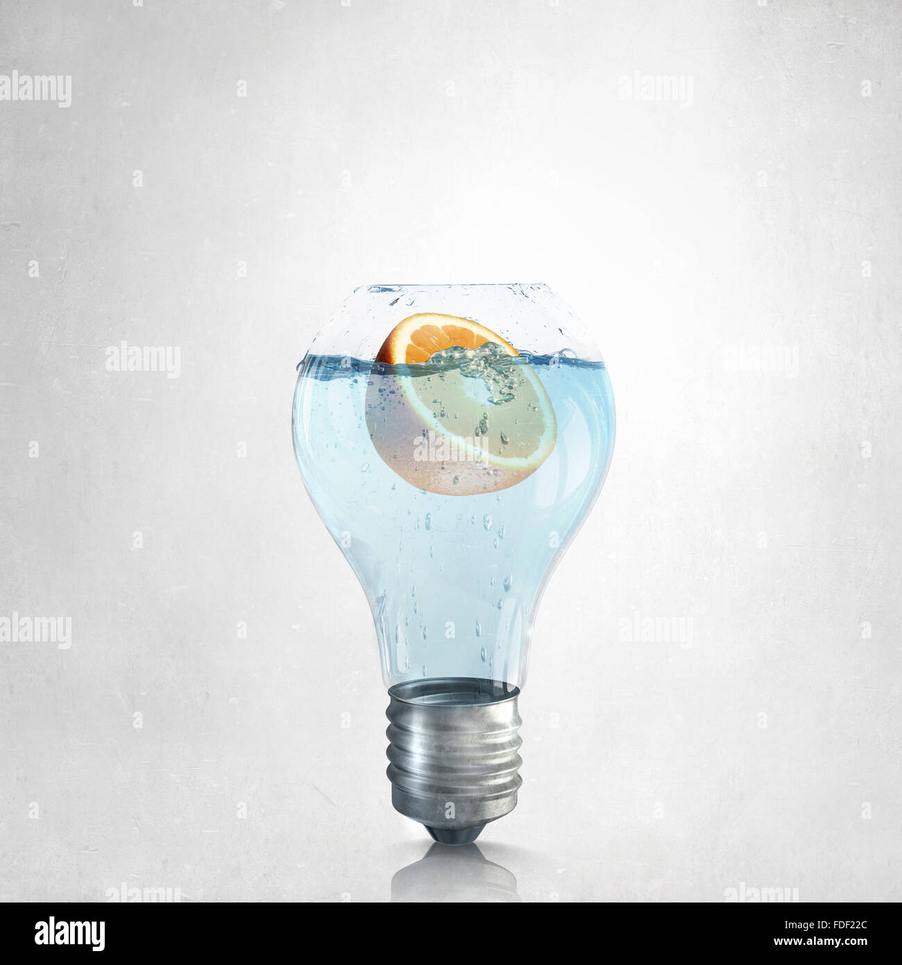 Glass lightbulb filled with water and half of orange fruit hi-res stock ...