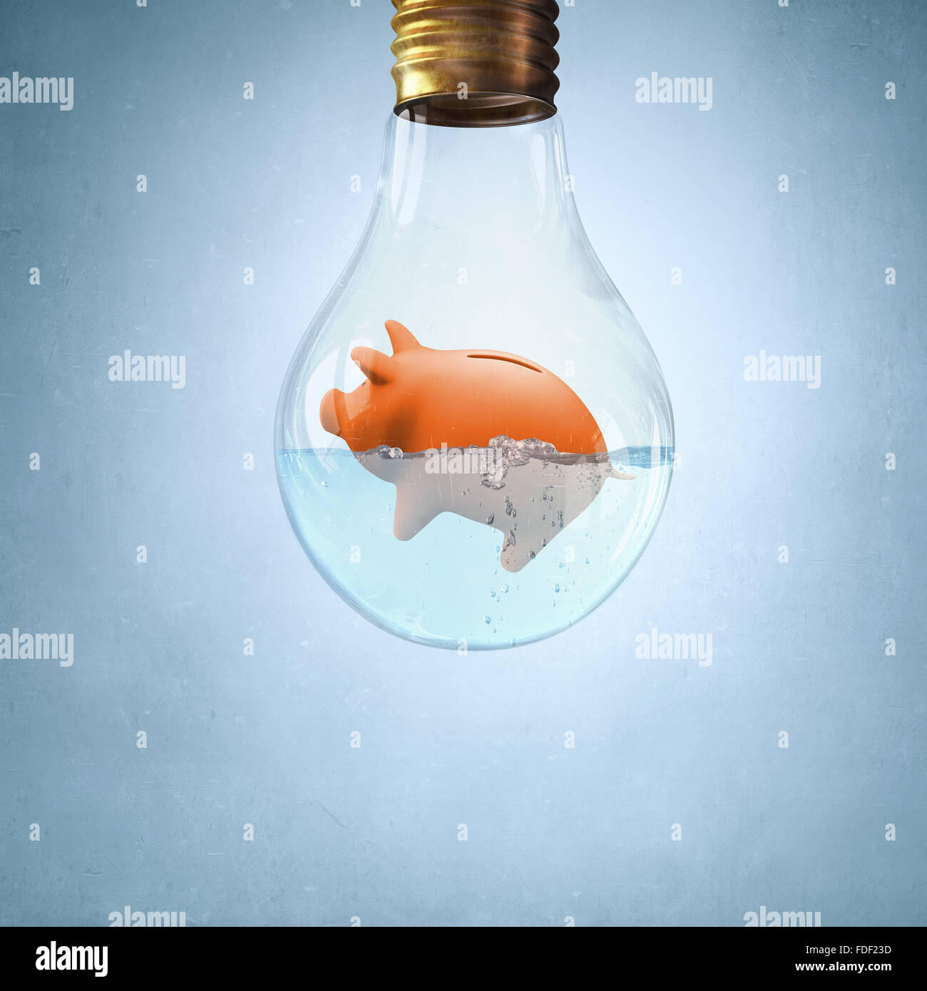 Glass light bulb with piggybank floating in water hi-res stock ...
