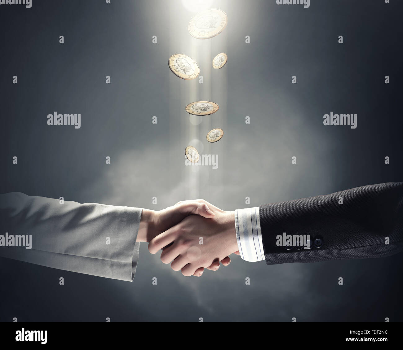 Handshake of business partners and coins at background Stock Photo - Alamy