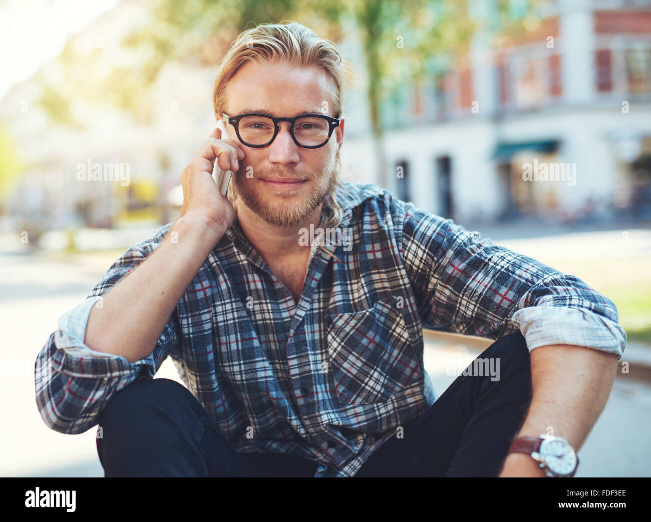 Outdoor portrait of modern young man with mobile phone in the street ...