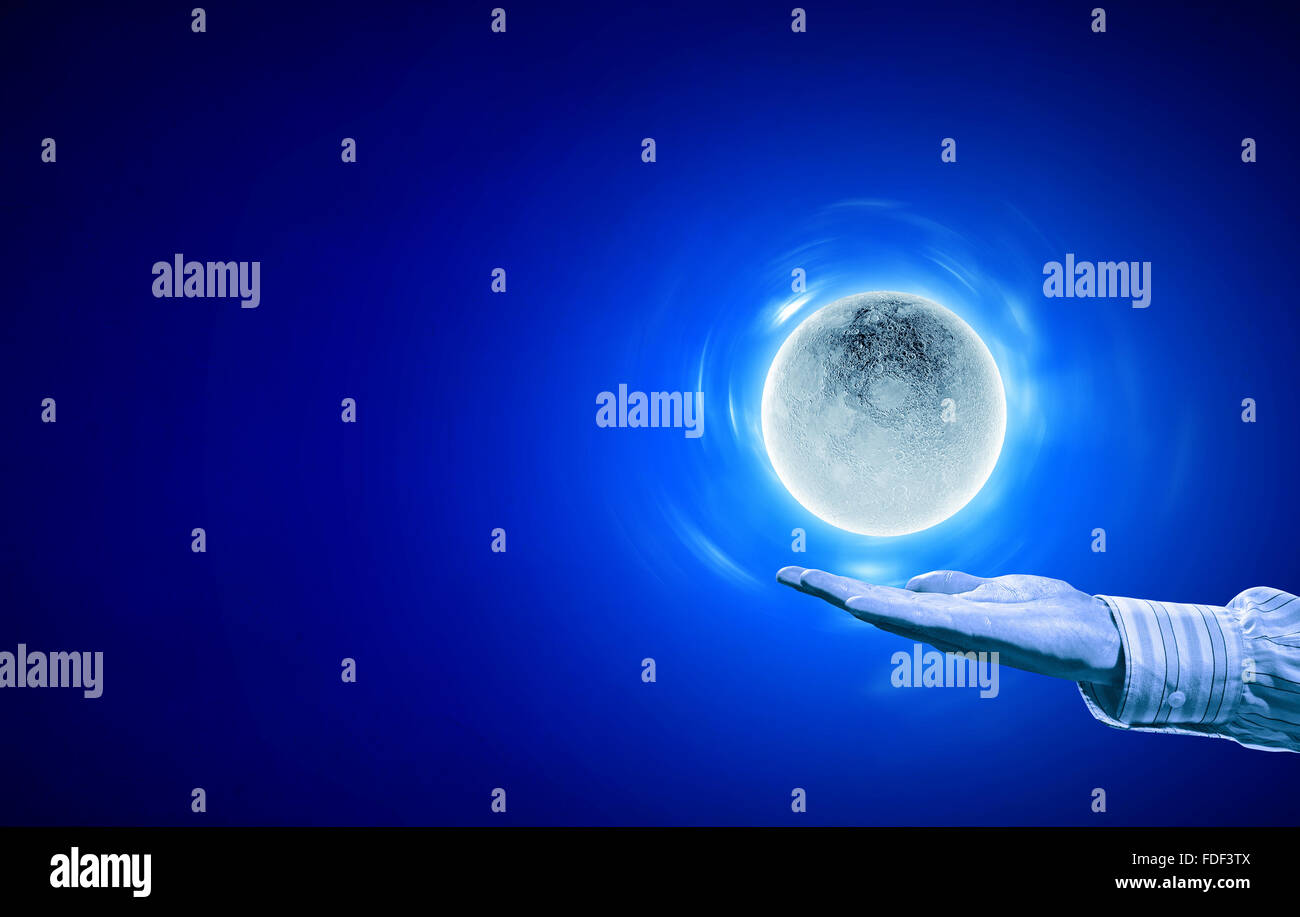 Person hand with moon on palm on blue background Stock Photo - Alamy