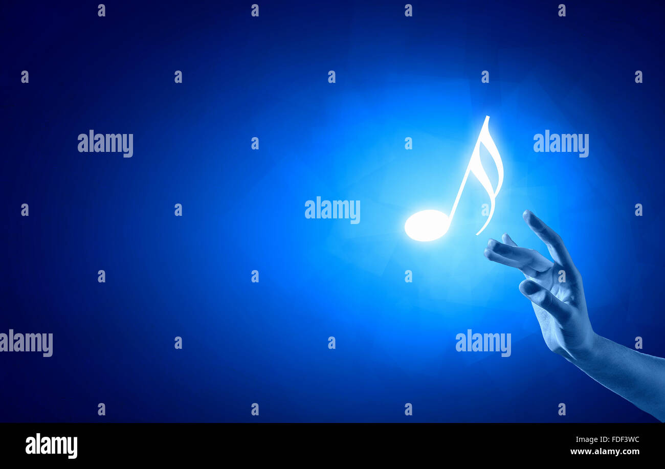 Close up of person hand touching music symbol on blue background Stock ...