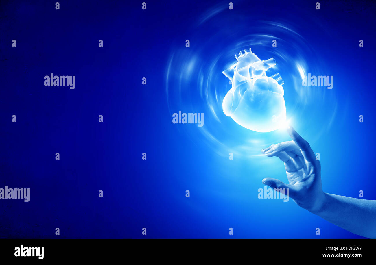 Close up of person hand touching human heart on blue background Stock ...