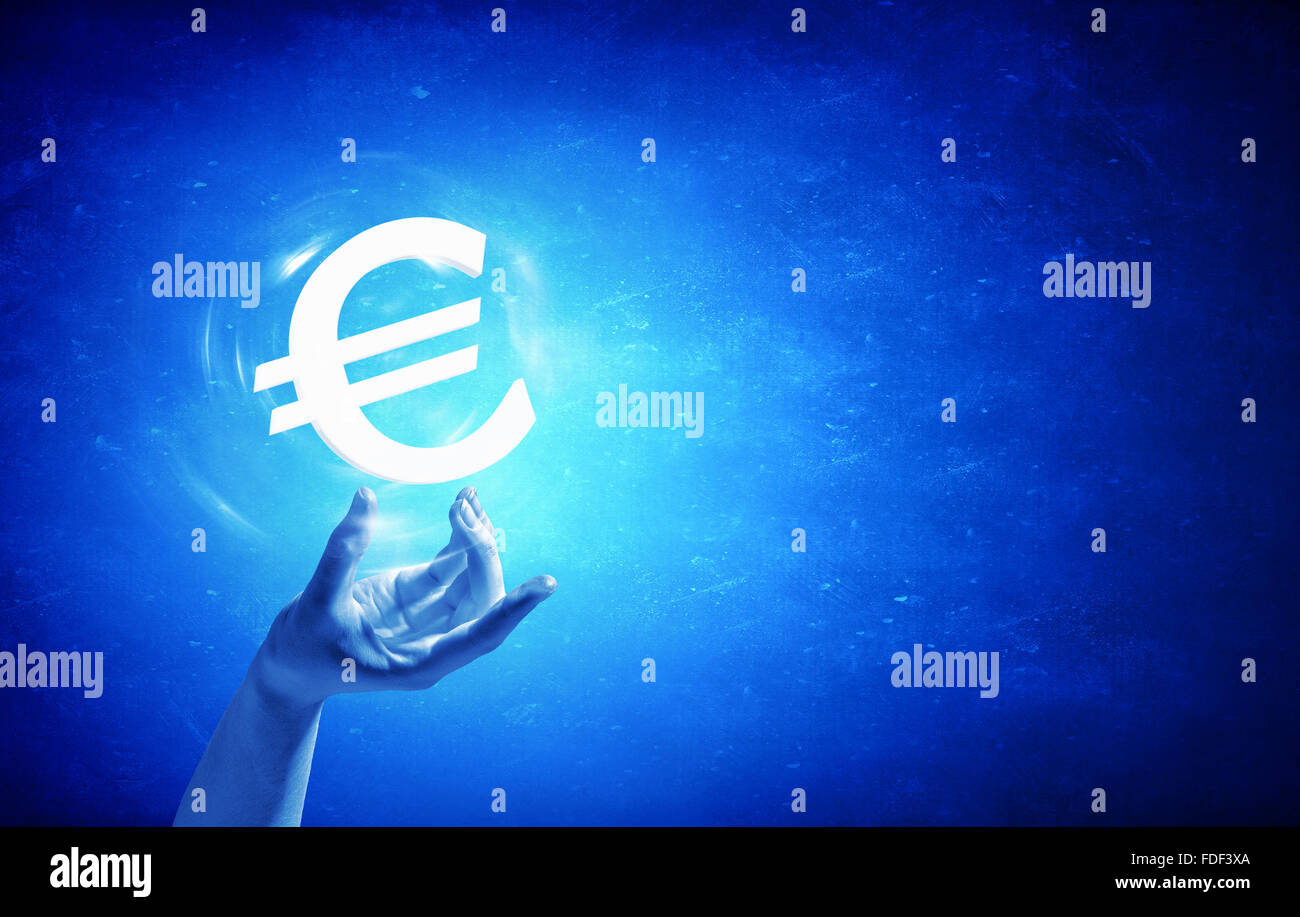 Close up of human hand holding euro symbol on blue background Stock ...