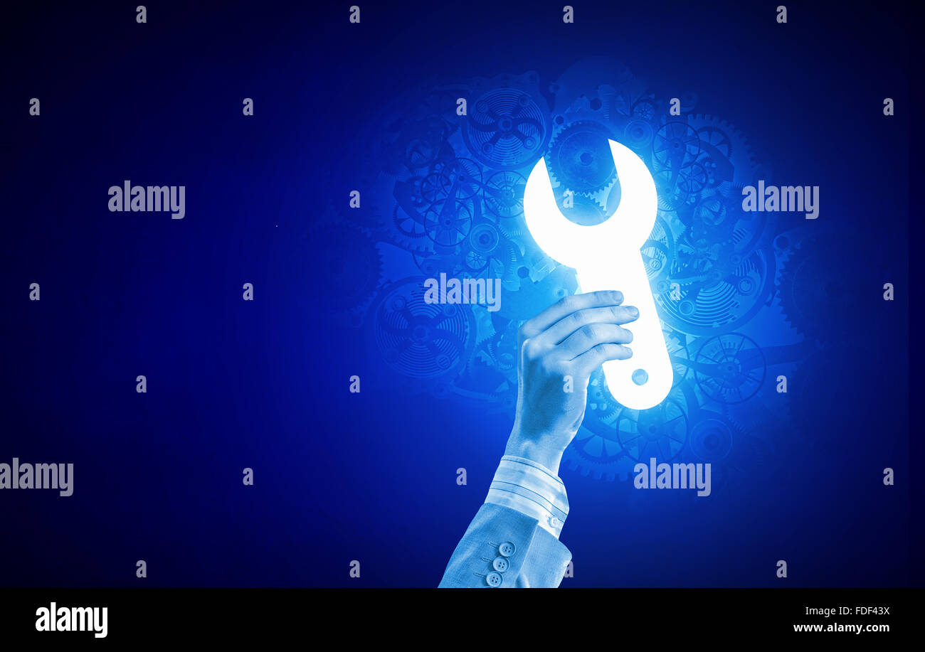 Person hand taking glowing tool sign on blue background Stock Photo - Alamy