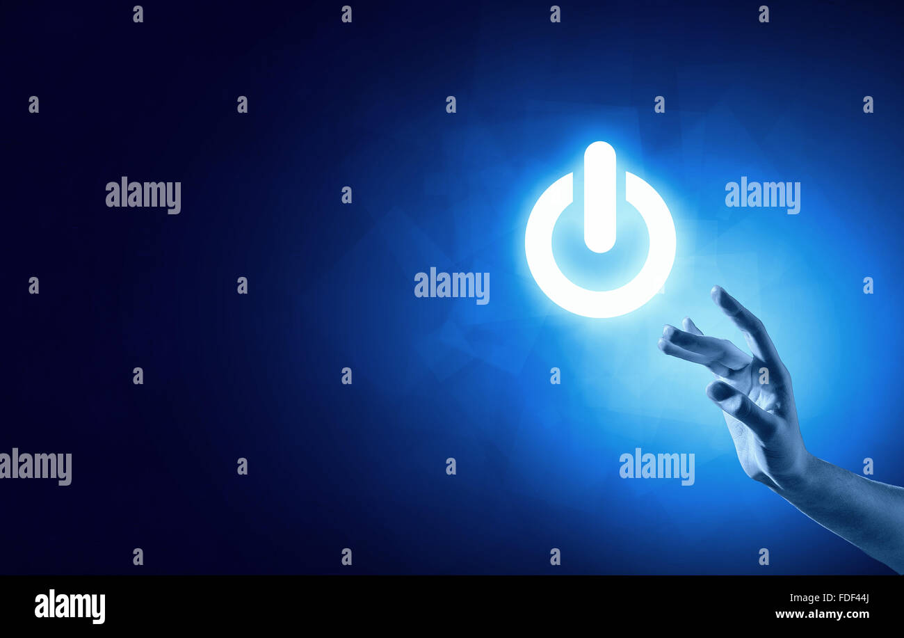 Hand pressing power button on blue background Stock Photo - Alamy