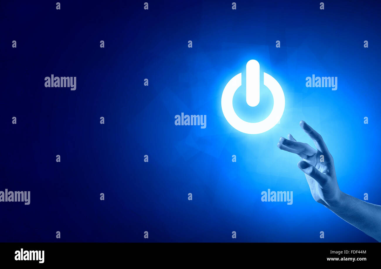 Hand pressing power button on blue background Stock Photo - Alamy