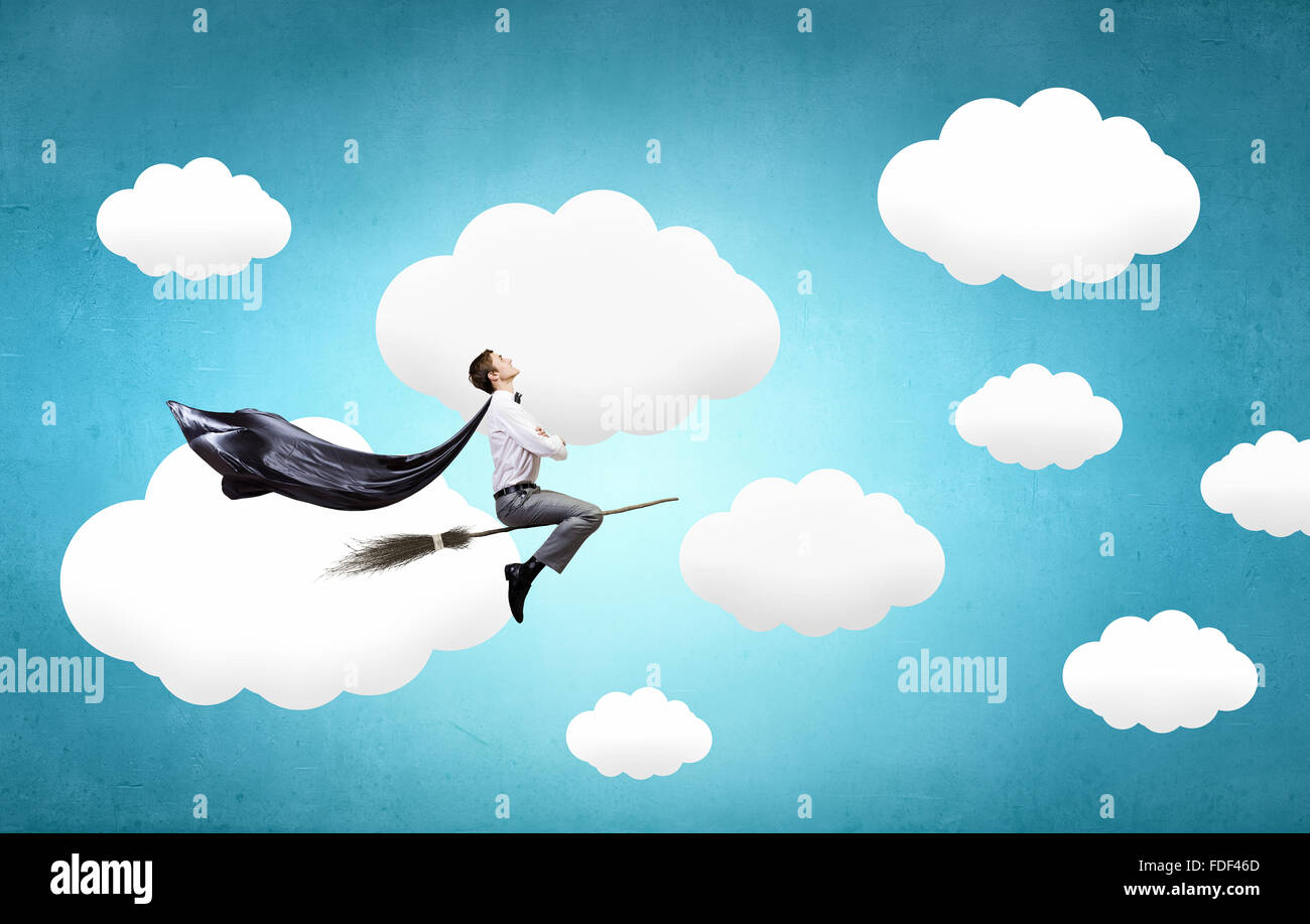 Young businessman flying on broom high in sky Stock Photo - Alamy