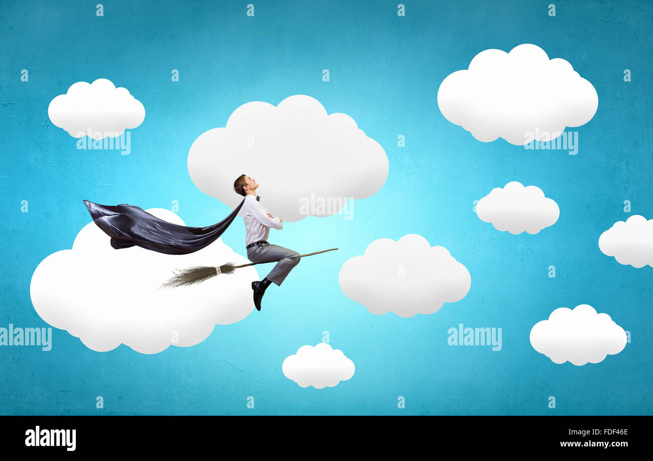 Young businessman flying on broom high in sky Stock Photo - Alamy
