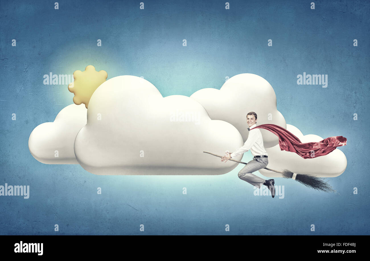 Young businessman flying on broom high in sky Stock Photo - Alamy