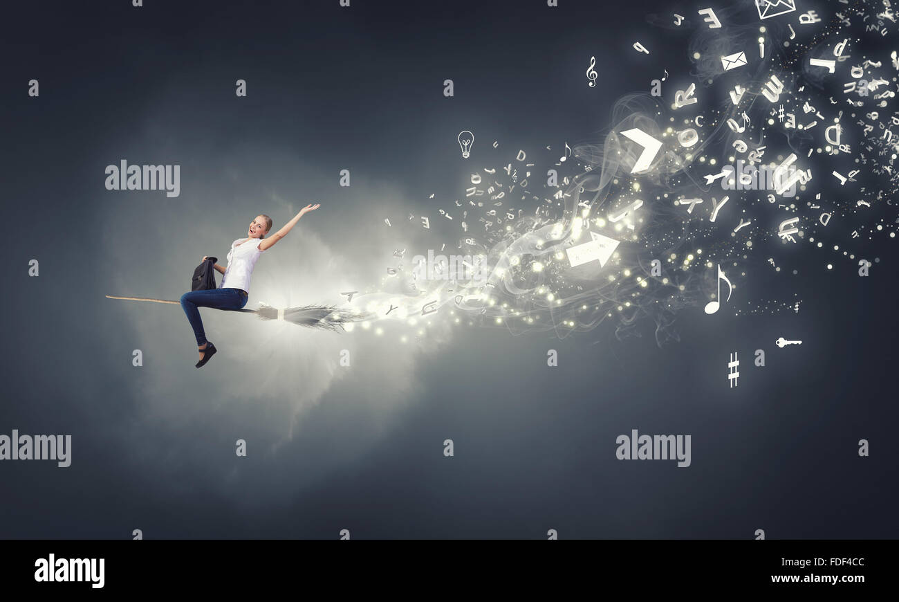 Happy young woman flying in sky on broom Stock Photo - Alamy