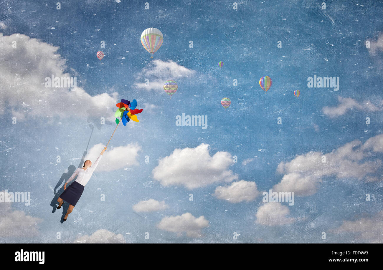 Beautiful young caucasian businesswoman flying on windmill Stock Photo ...