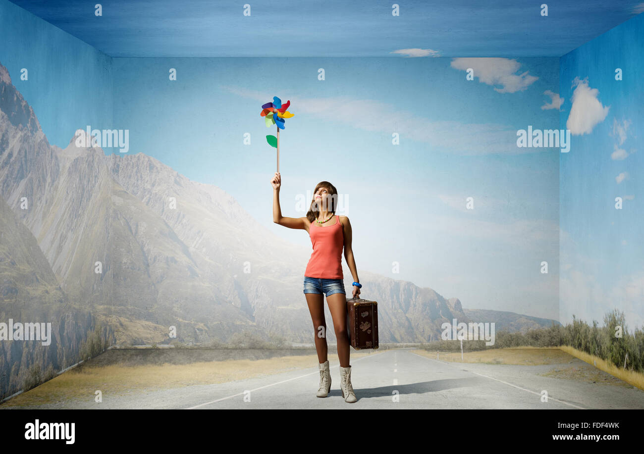 Happy young woman with windmill in hand Stock Photo - Alamy
