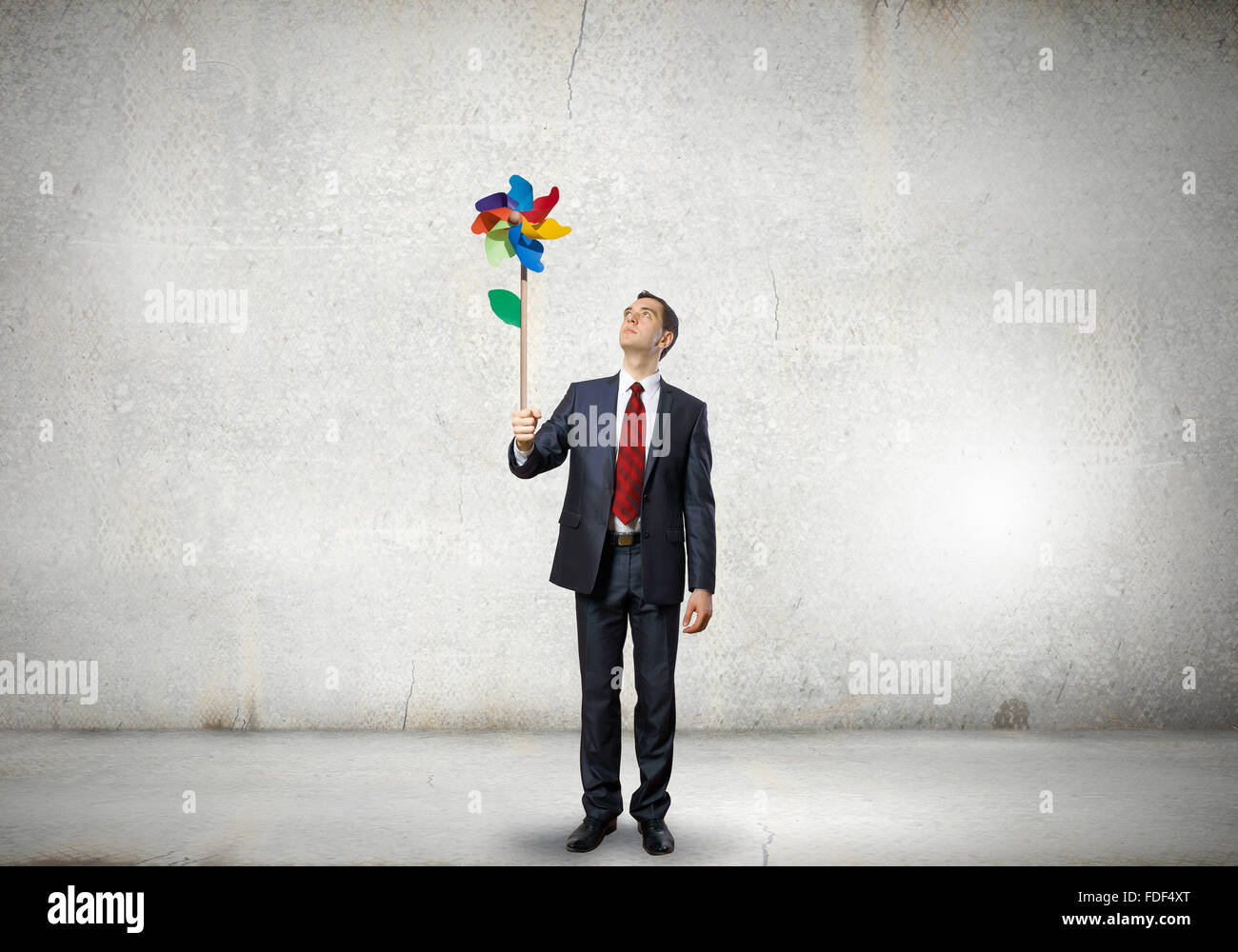 Young happy businessman with colorful windmill in hand Stock Photo - Alamy