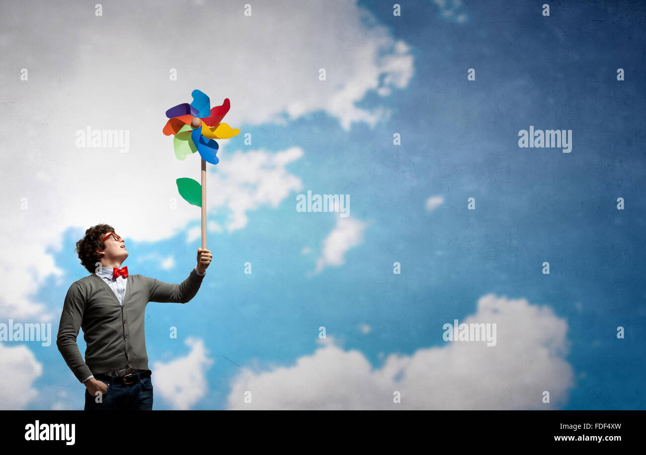 Young happy guy in casual with colorful windmill in hand Stock Photo ...