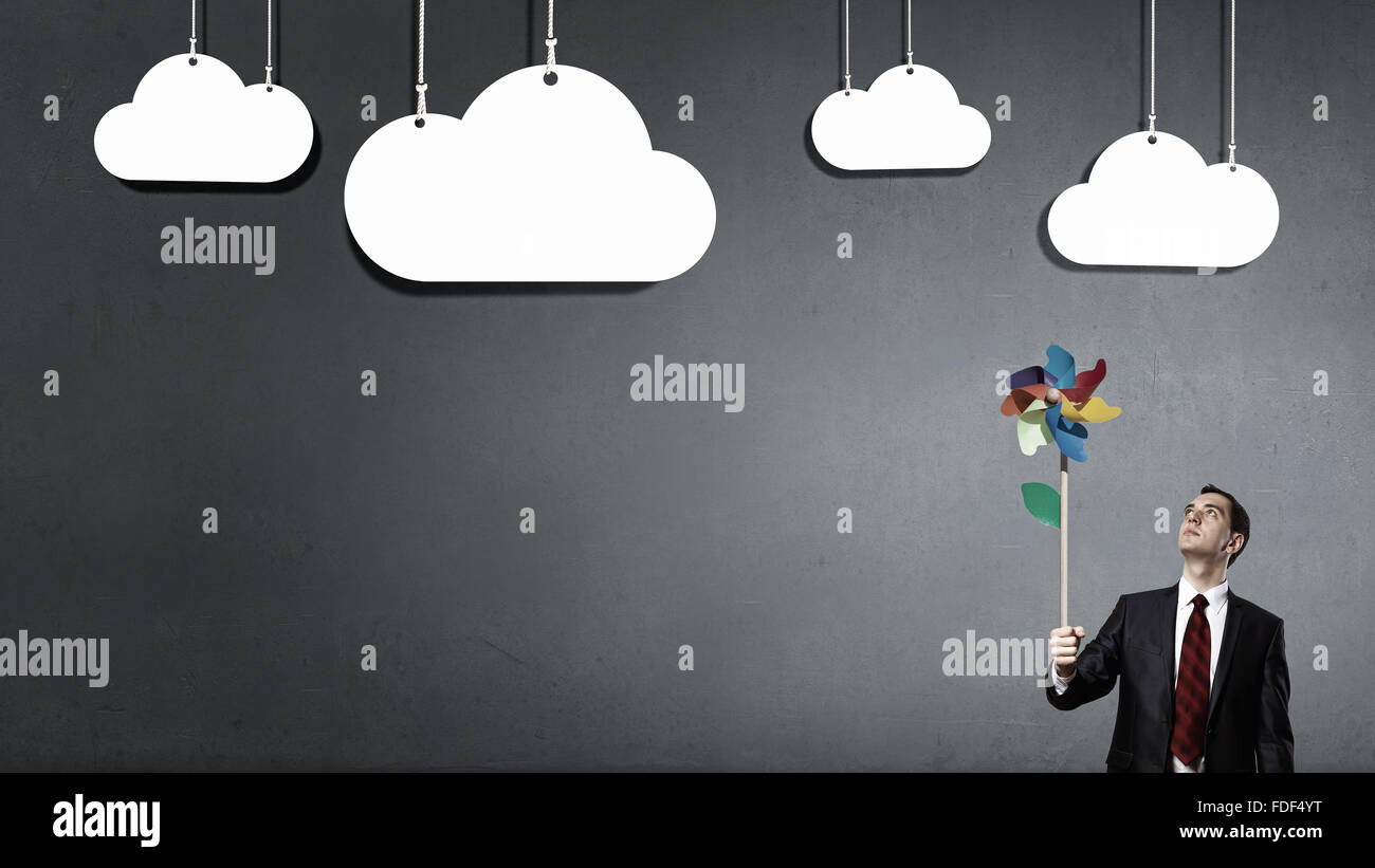 Young happy businessman with colorful windmill in hand Stock Photo - Alamy