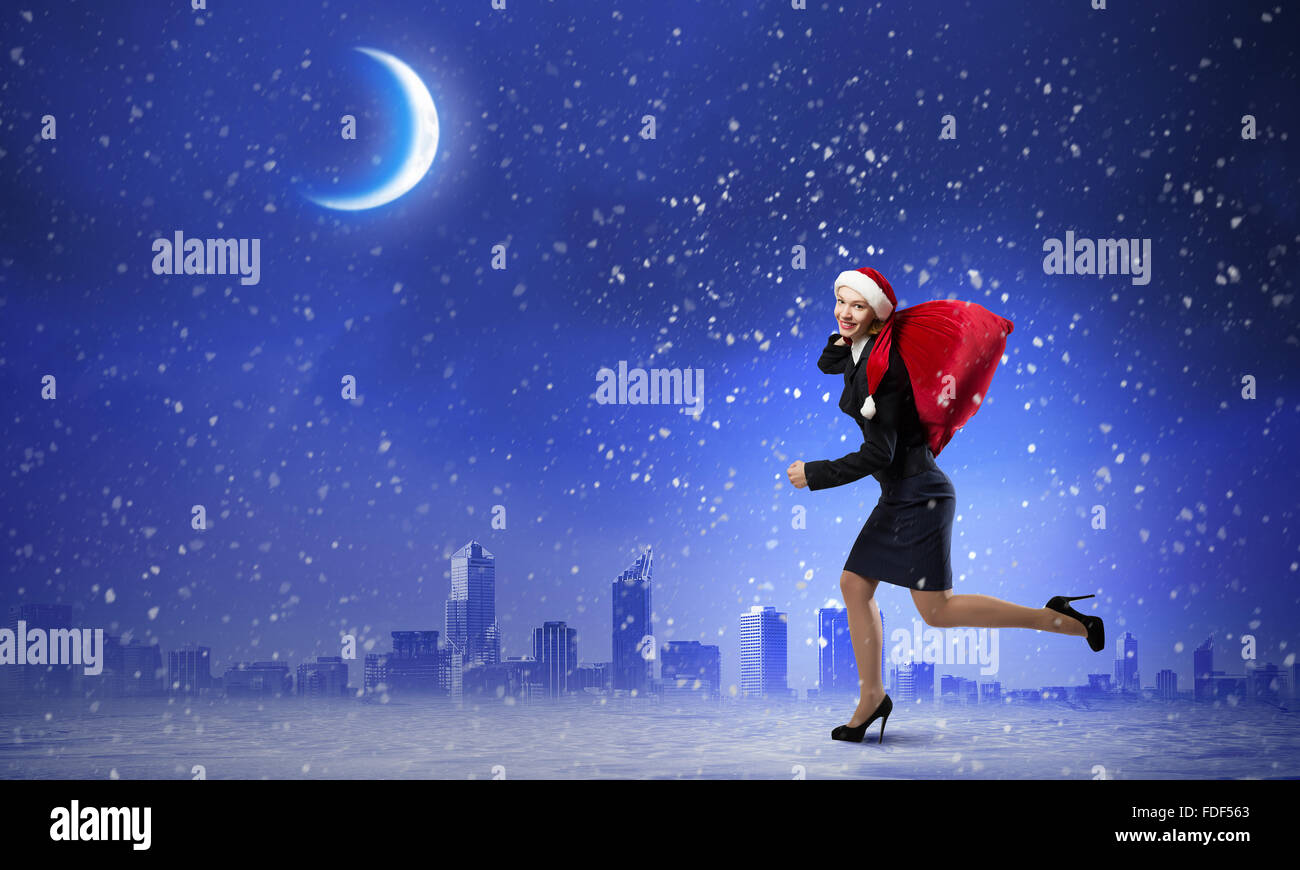 Santa woman running with red gift bag on back Stock Photo - Alamy