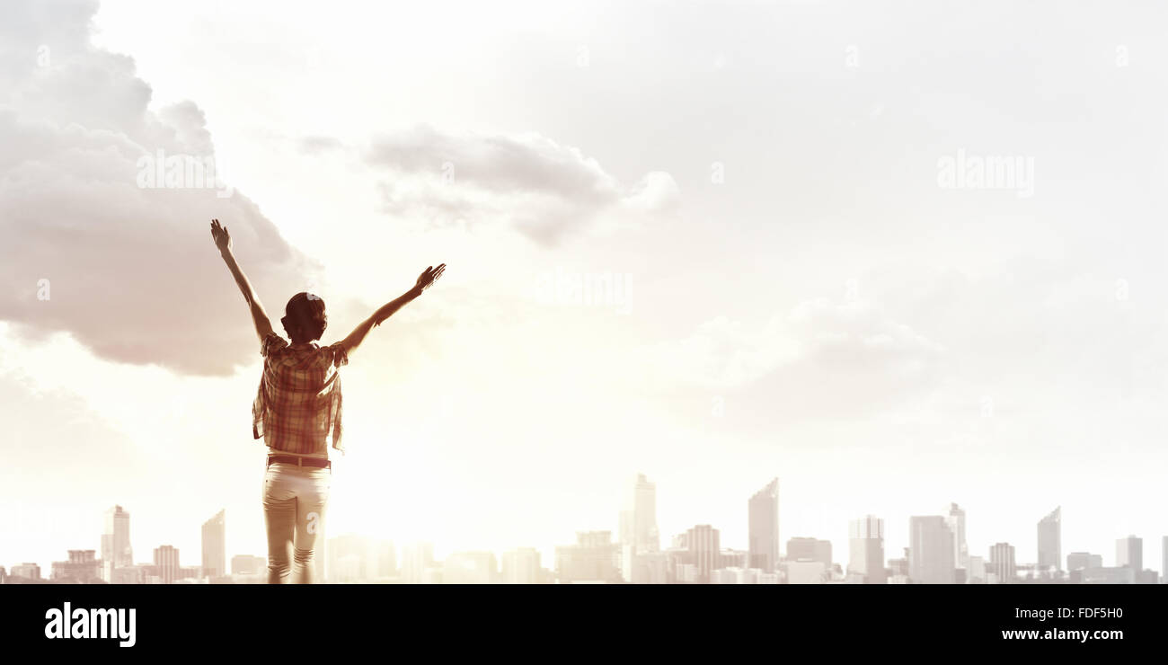 Back view of cheerful woman with hands up facing sunrise Stock Photo ...