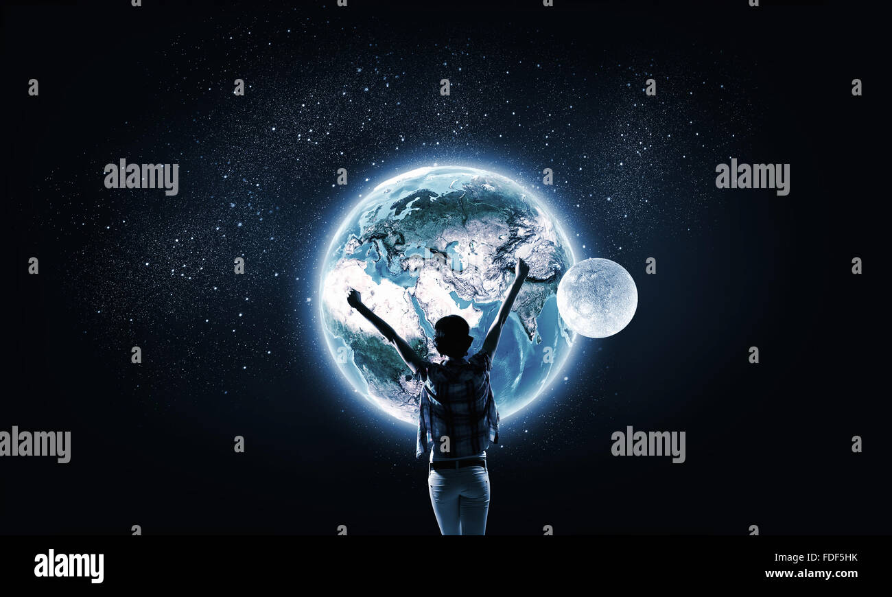 Back view of girl with hands up looking at planets. Elements of this ...