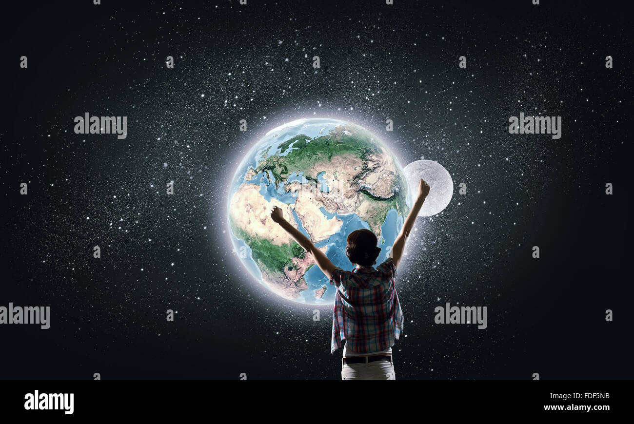 Back view of girl with hands up looking at planets. Elements of this ...