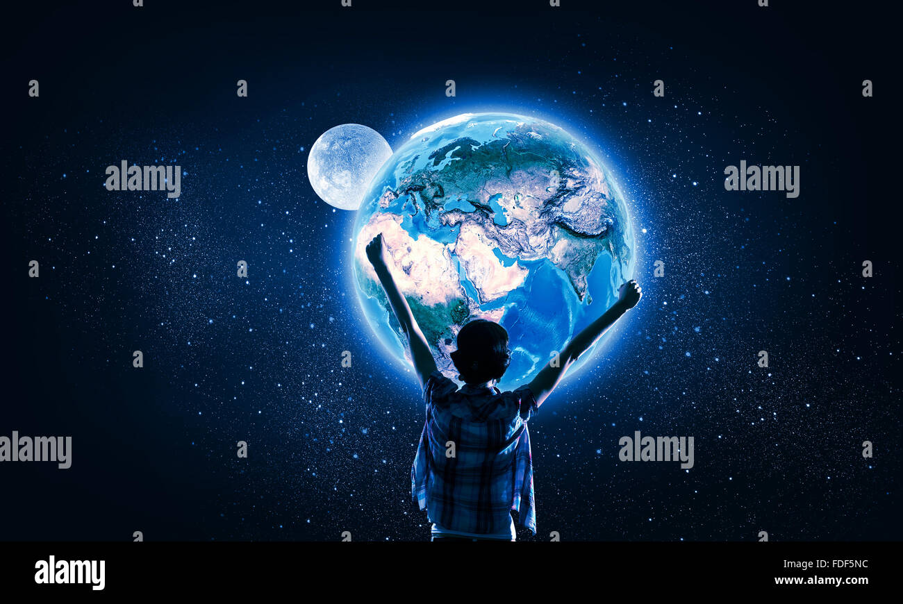 Back view of girl with hands up looking at planets. Elements of this ...