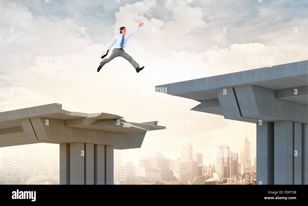 Businessman jumping over a gap in the bridge as a symbol of bridge ...
