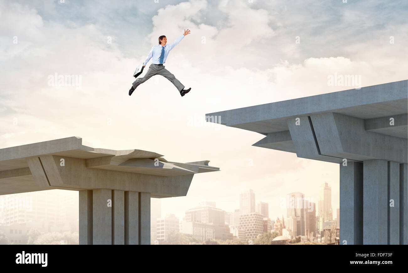 Businessman jumping over a gap in the bridge as a symbol of bridge ...