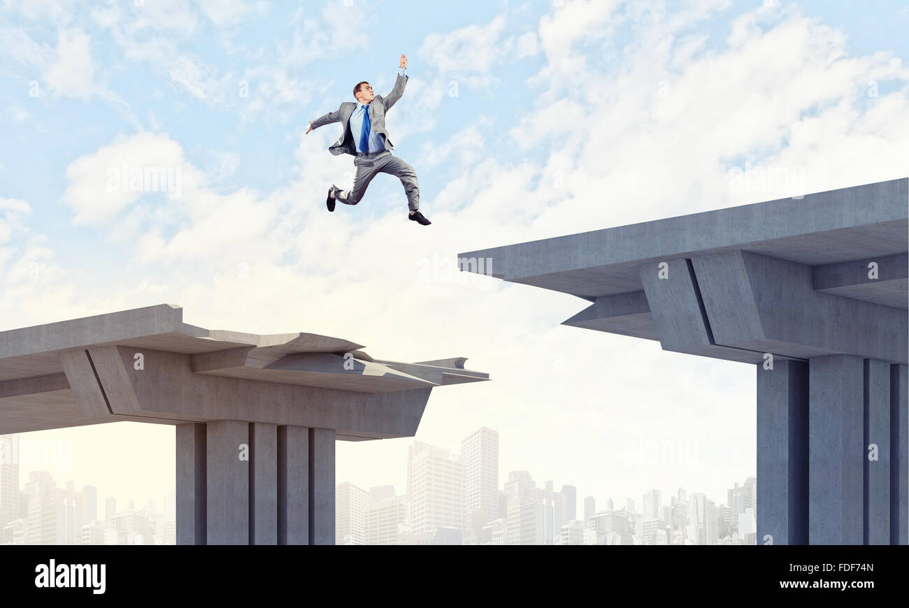 Businessman jumping over a gap in the bridge as a symbol of bridge ...