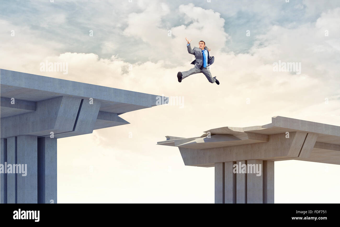 Businessman jumping over a gap in the bridge as a symbol of bridge ...