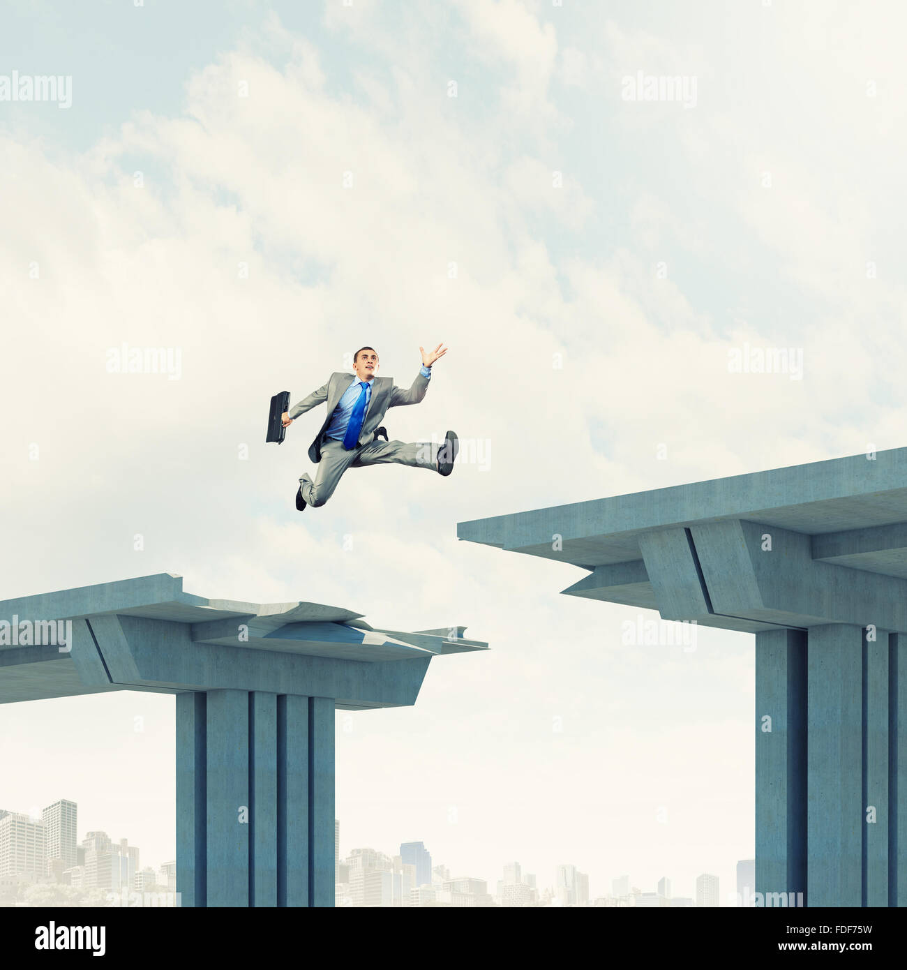 Businessman jumping over a gap in the bridge as a symbol of bridge ...