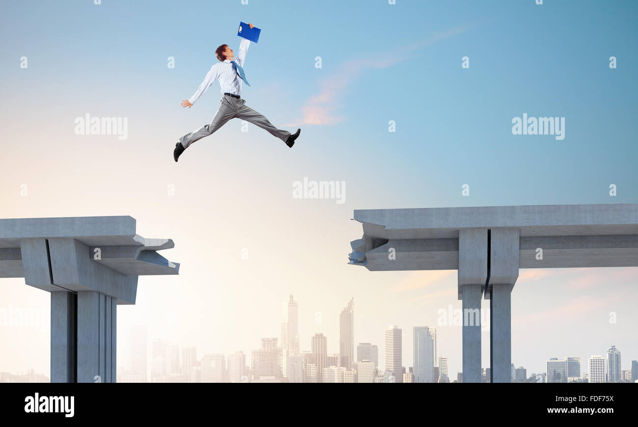 Businessman jumping over a gap in the bridge as a symbol of bridge ...