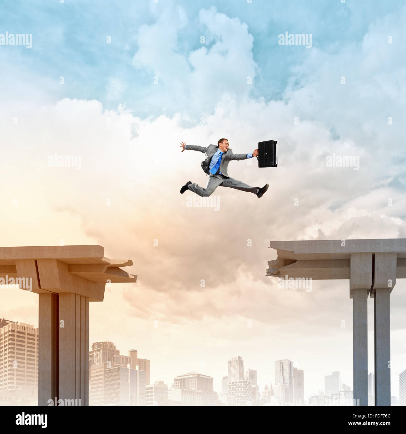 Businessman jumping over a gap in the bridge as a symbol of bridge ...