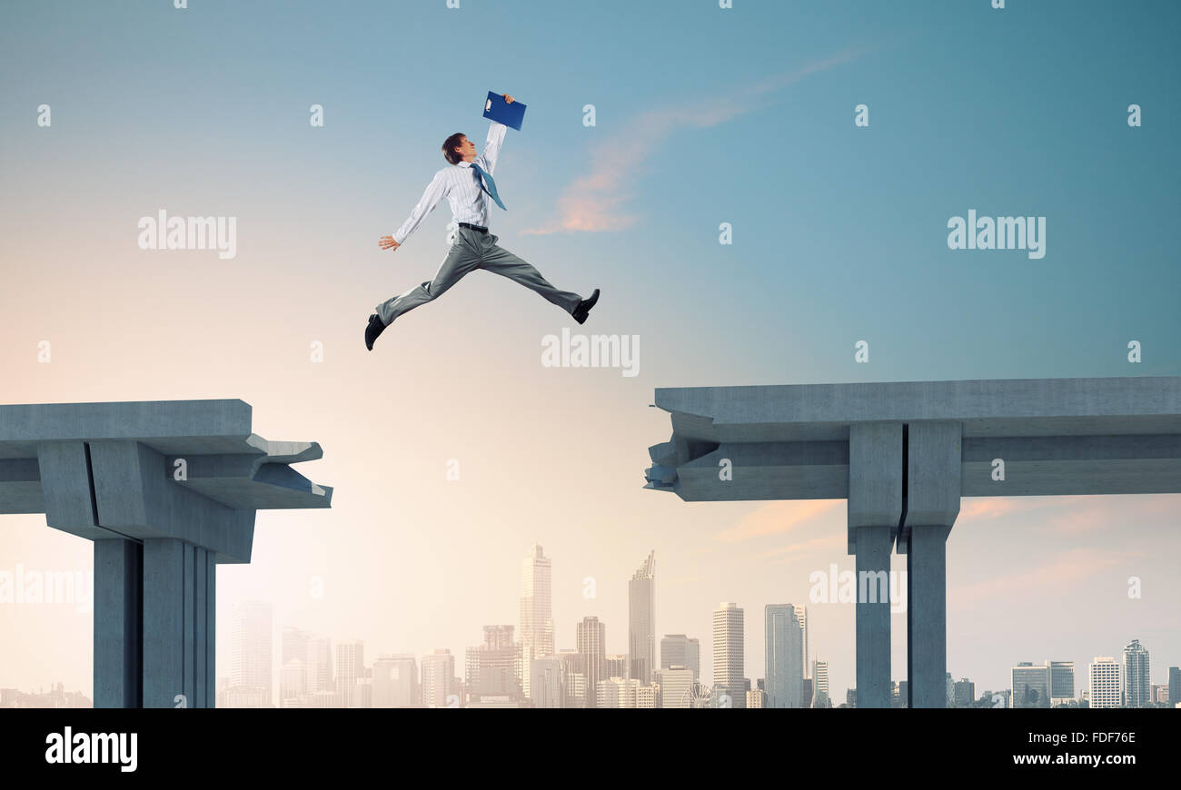Businessman jumping over a gap in the bridge as a symbol of bridge ...