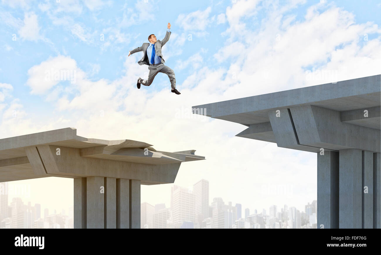 Businessman jumping over a gap in the bridge as a symbol of bridge ...