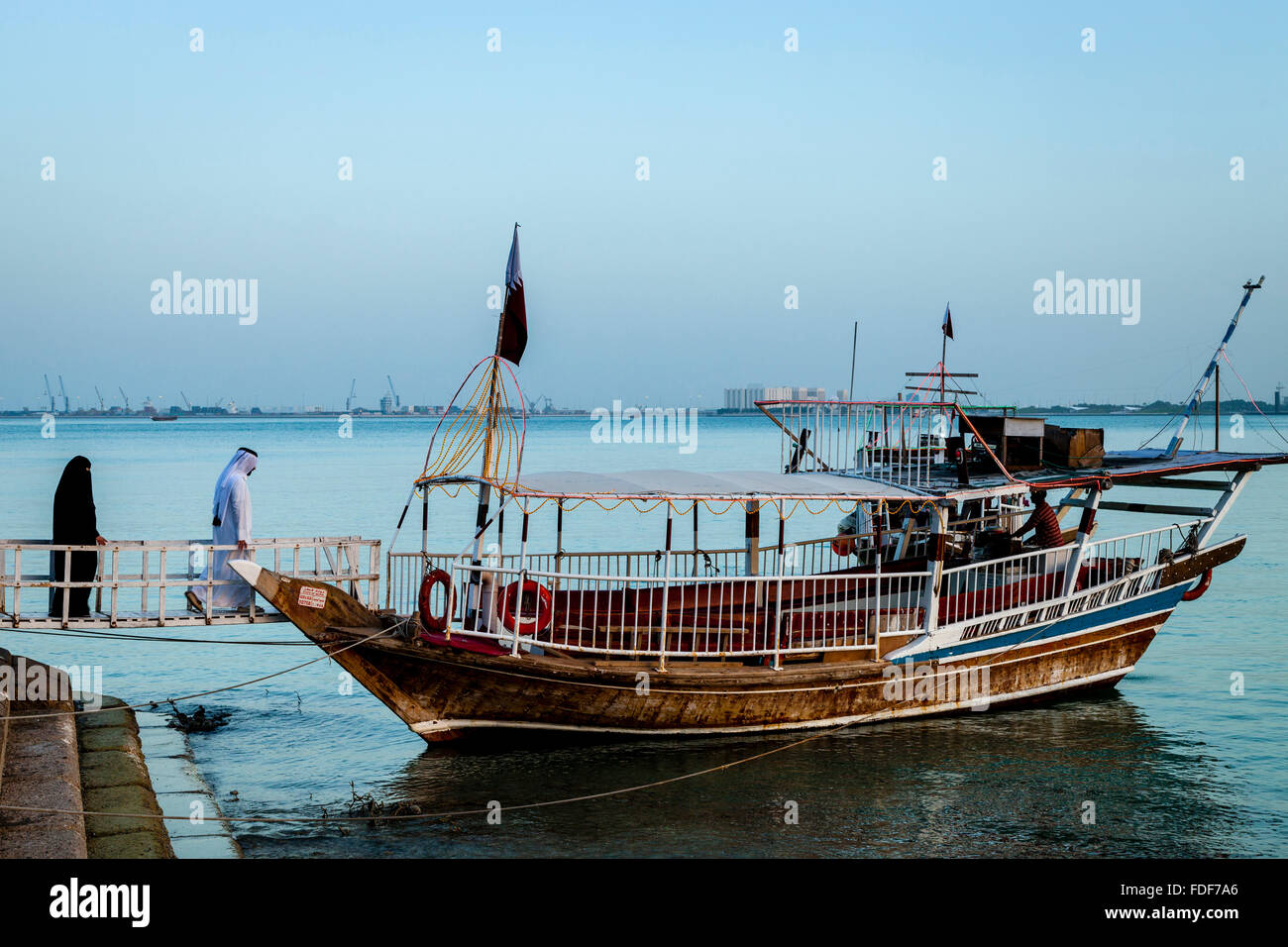 A Traditional Qatari Couple Board A Dhow For A Cruise, Doha, Qatar ...