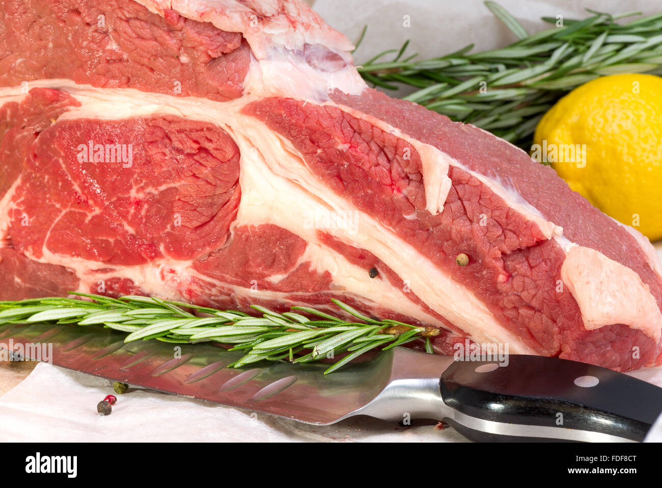 raw meat - beef. Knife, lemon and seasonings Stock Photo - Alamy