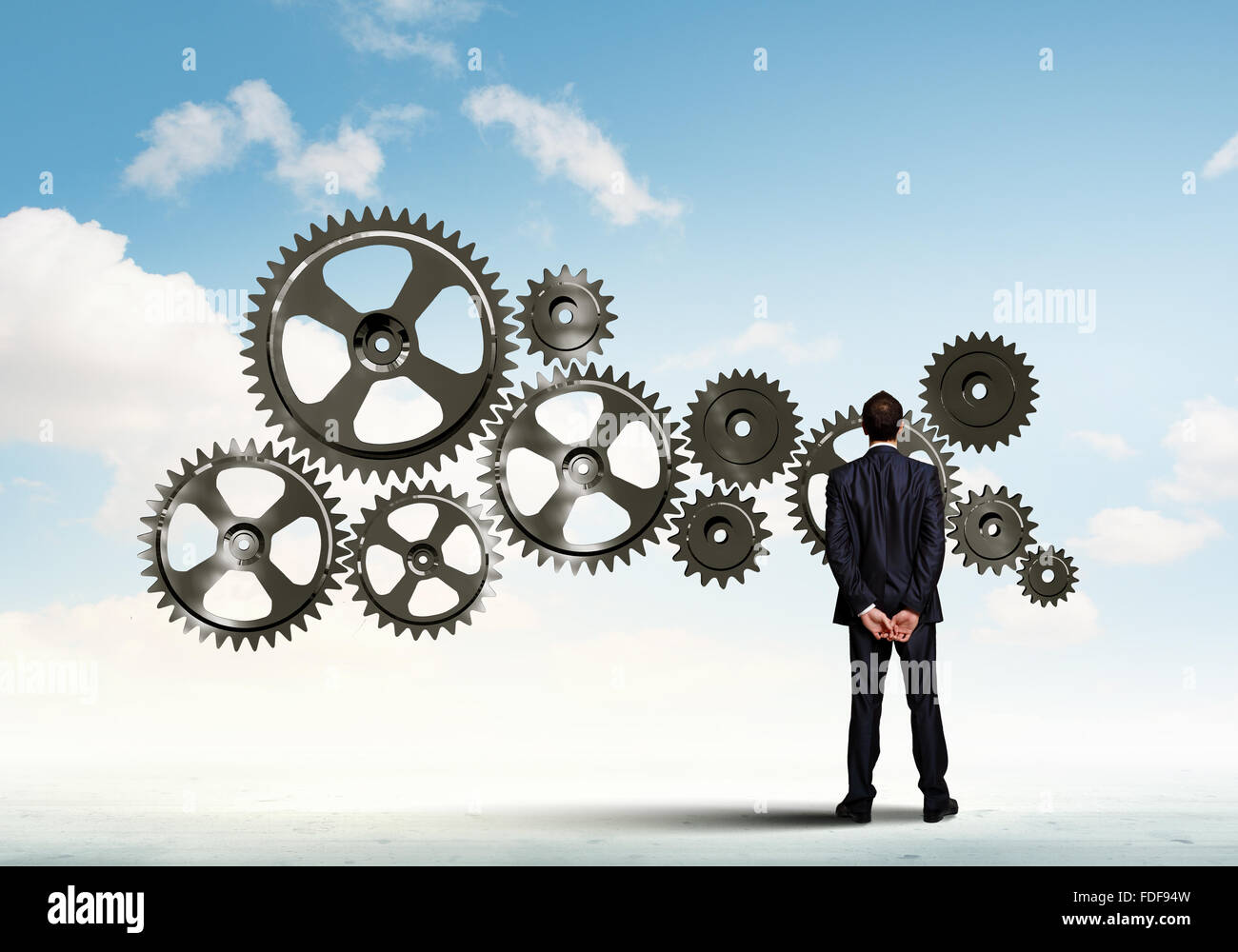 Businessman with cog wheel elements. Construction concept Stock Photo ...