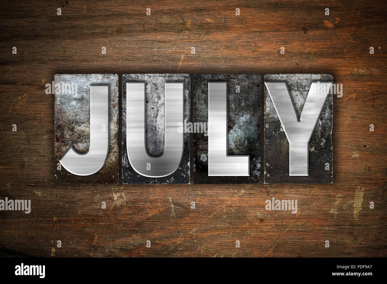 The word "July" written in vintage metal letterpress type on an aged ...