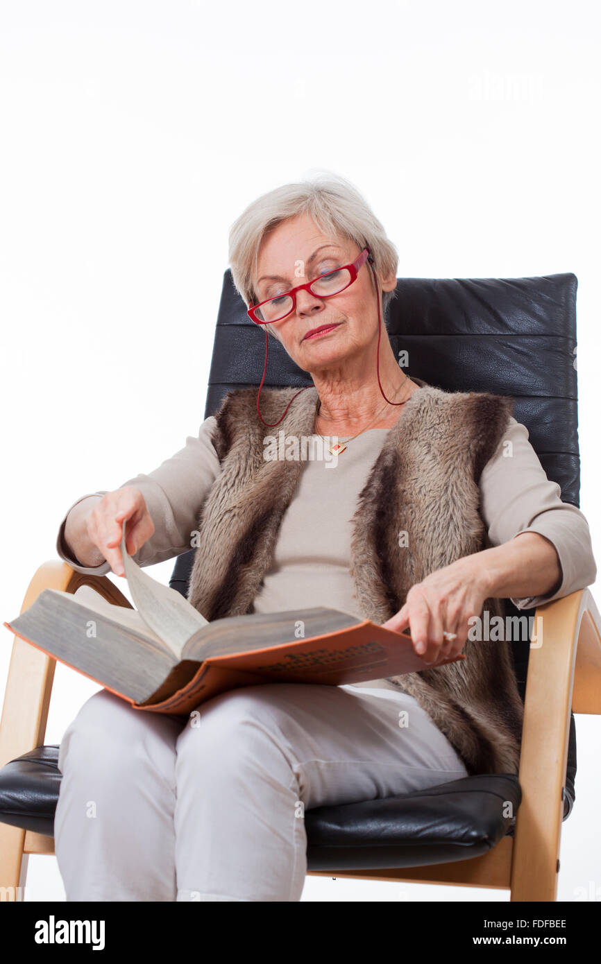 smiling senior old woman reading book in chair Stock Photo - Alamy