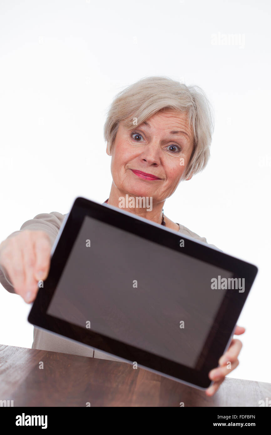 happy old senior woman holding tablet for advertising smiling Stock ...