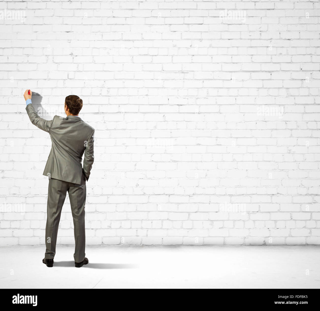 Back view image of businessman drawing on wall Stock Photo - Alamy