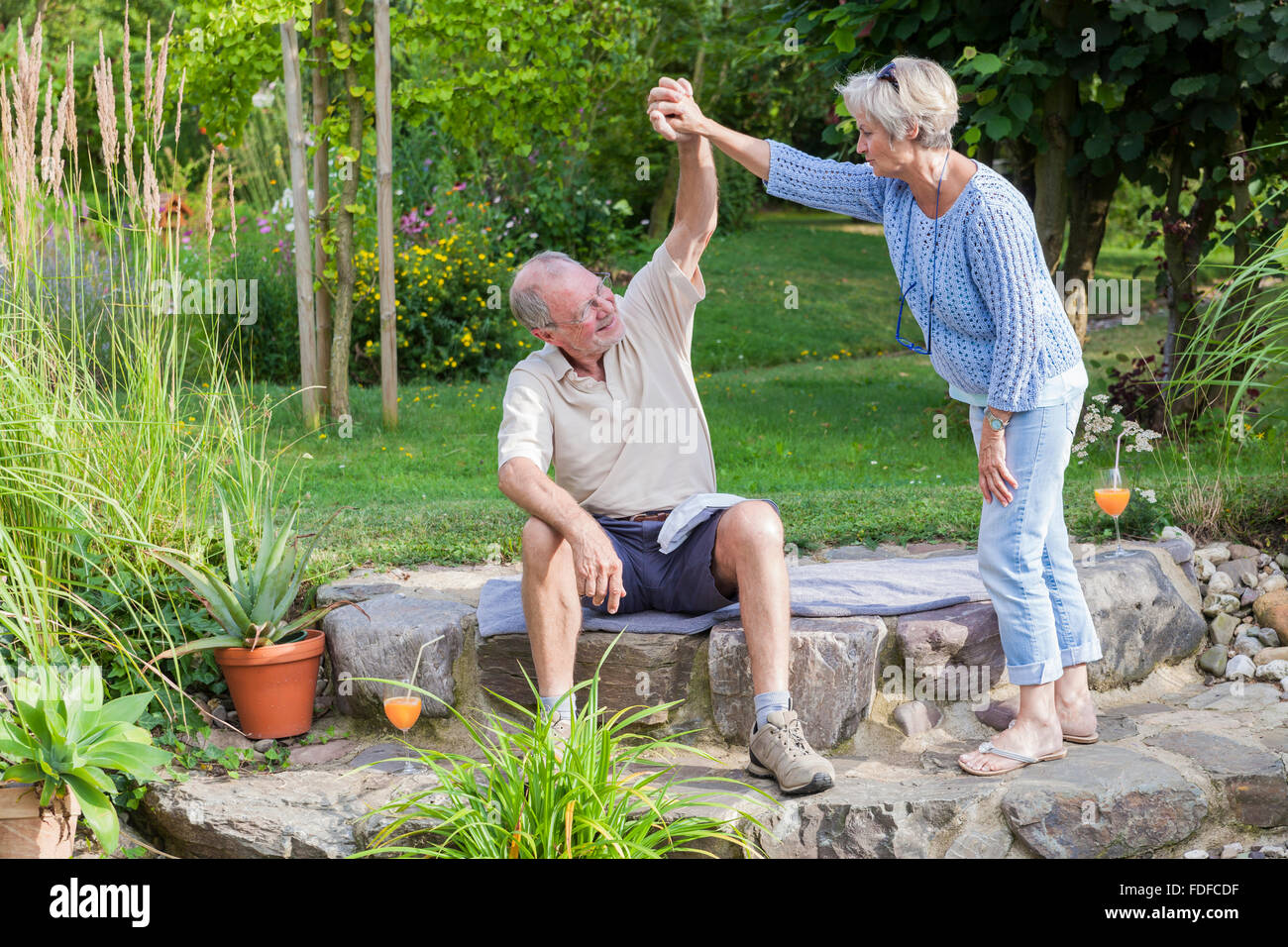 happy senior couple in garden smiling and laughing in sunshine enjoying ...