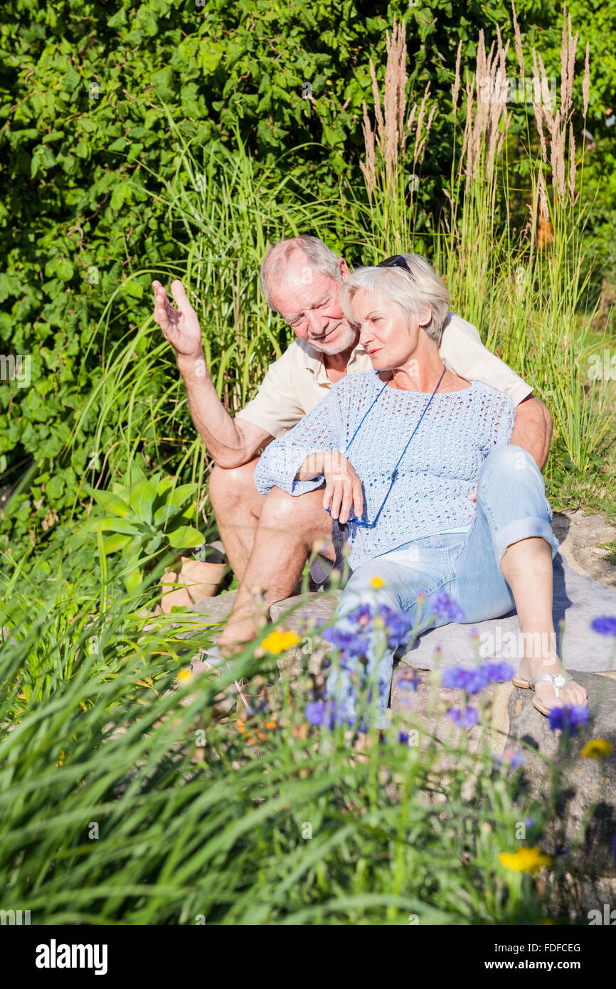 happy senior couple in garden smiling and laughing in sunshine enjoying ...