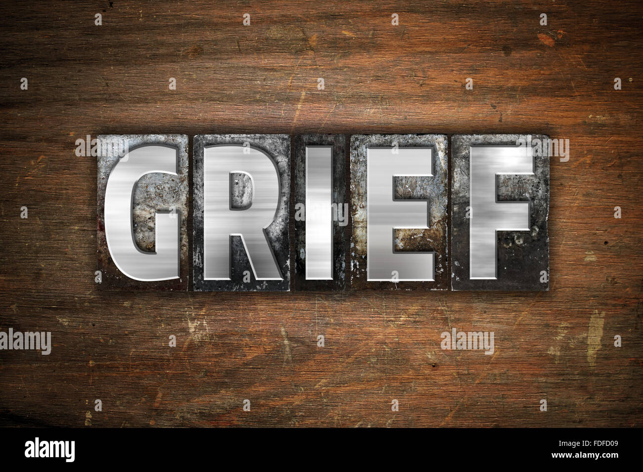 The word "Grief" written in vintage metal letterpress type on an aged ...