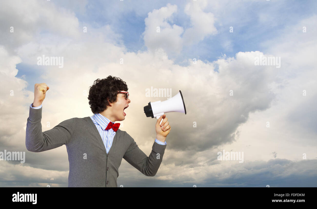 Portrait of young man shouting loudly using megaphone Stock Photo - Alamy