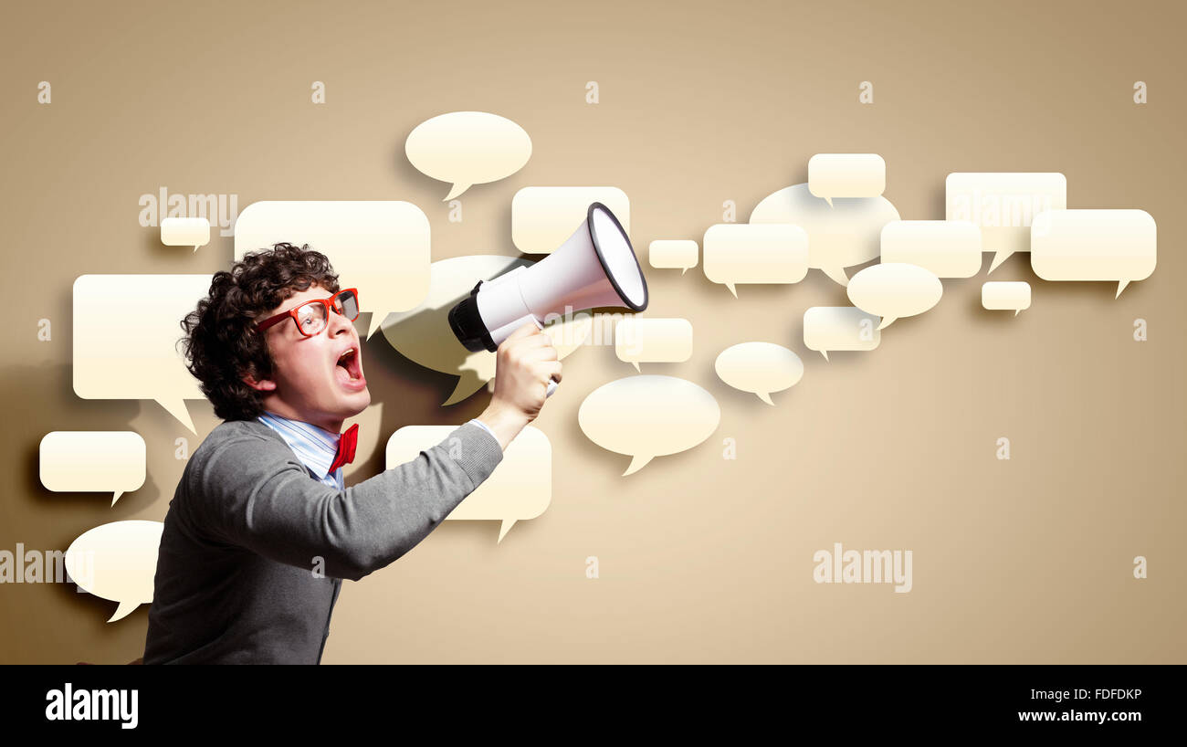 Portrait of young man shouting loudly using megaphone Stock Photo - Alamy