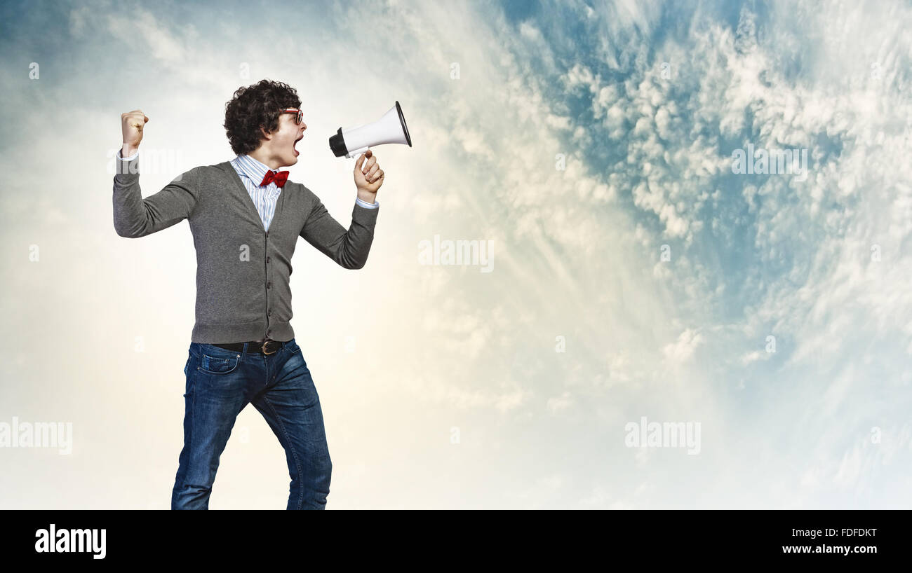Portrait of young man shouting loudly using megaphone Stock Photo - Alamy