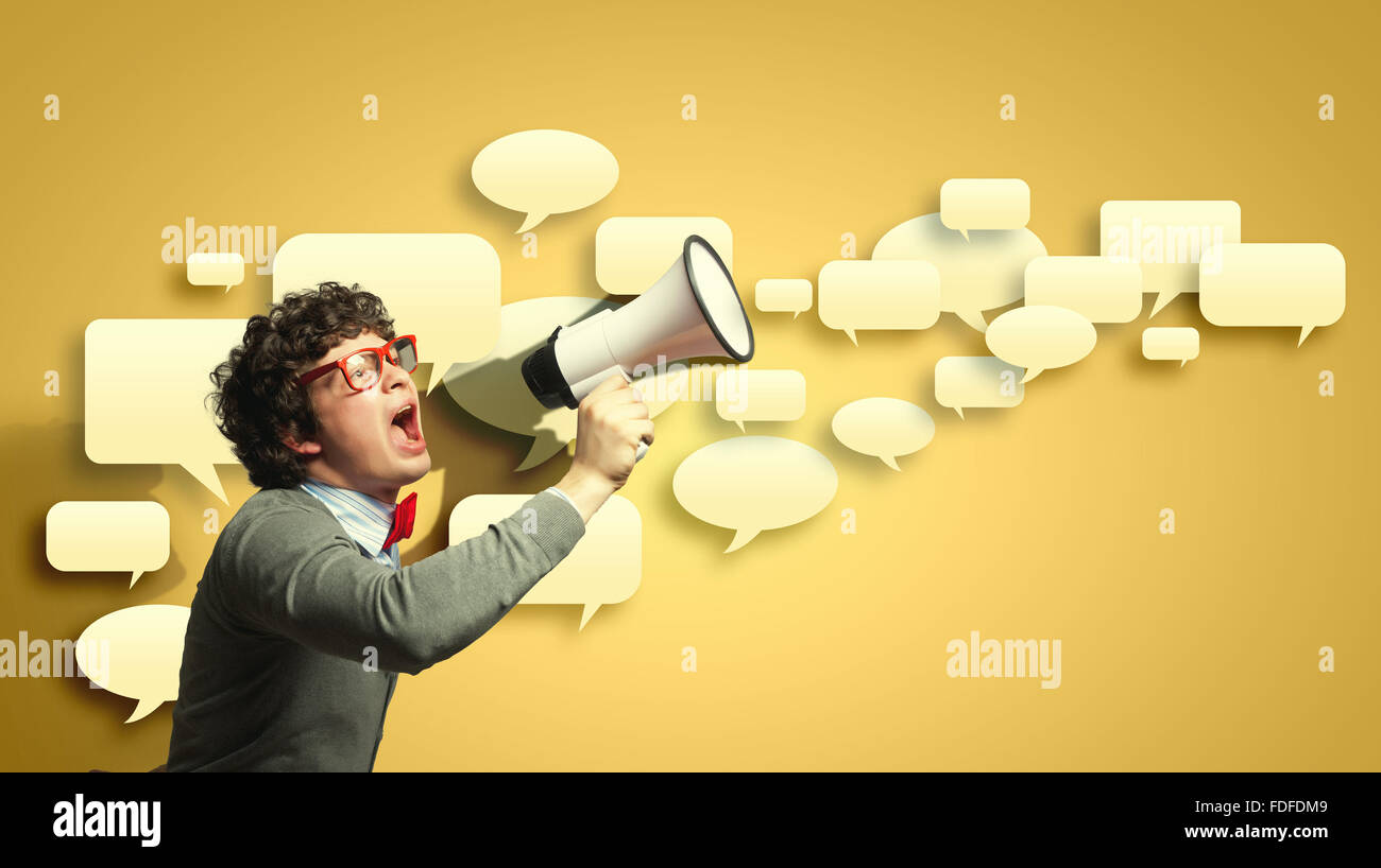 Portrait of young man shouting loudly using megaphone Stock Photo - Alamy