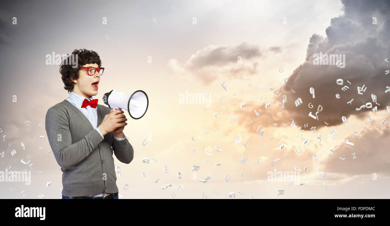 Portrait of young man shouting loudly using megaphone Stock Photo - Alamy