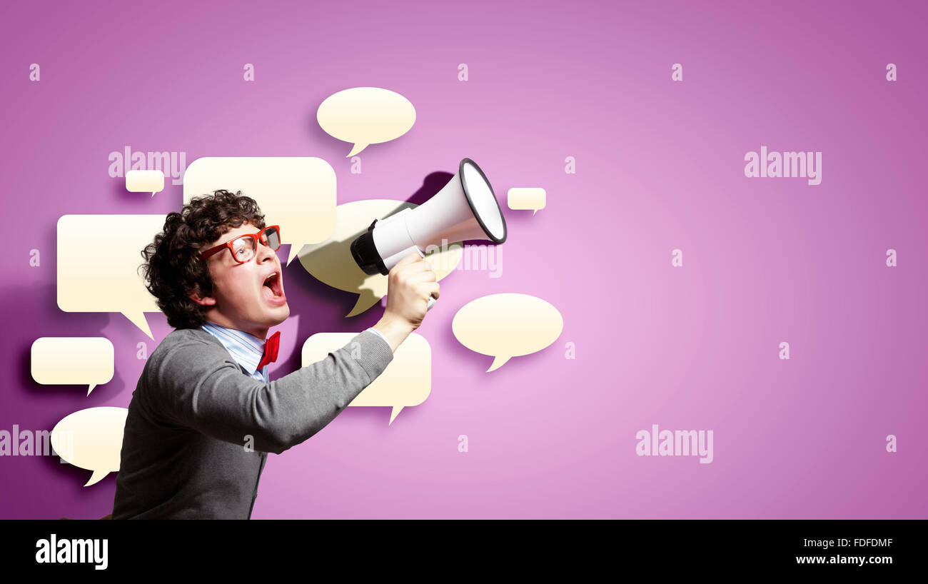 Portrait of young man shouting loudly using megaphone Stock Photo - Alamy